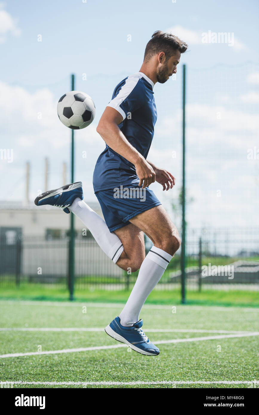 athletic soccer player training with ball on soccer pitch Stock Photo ...