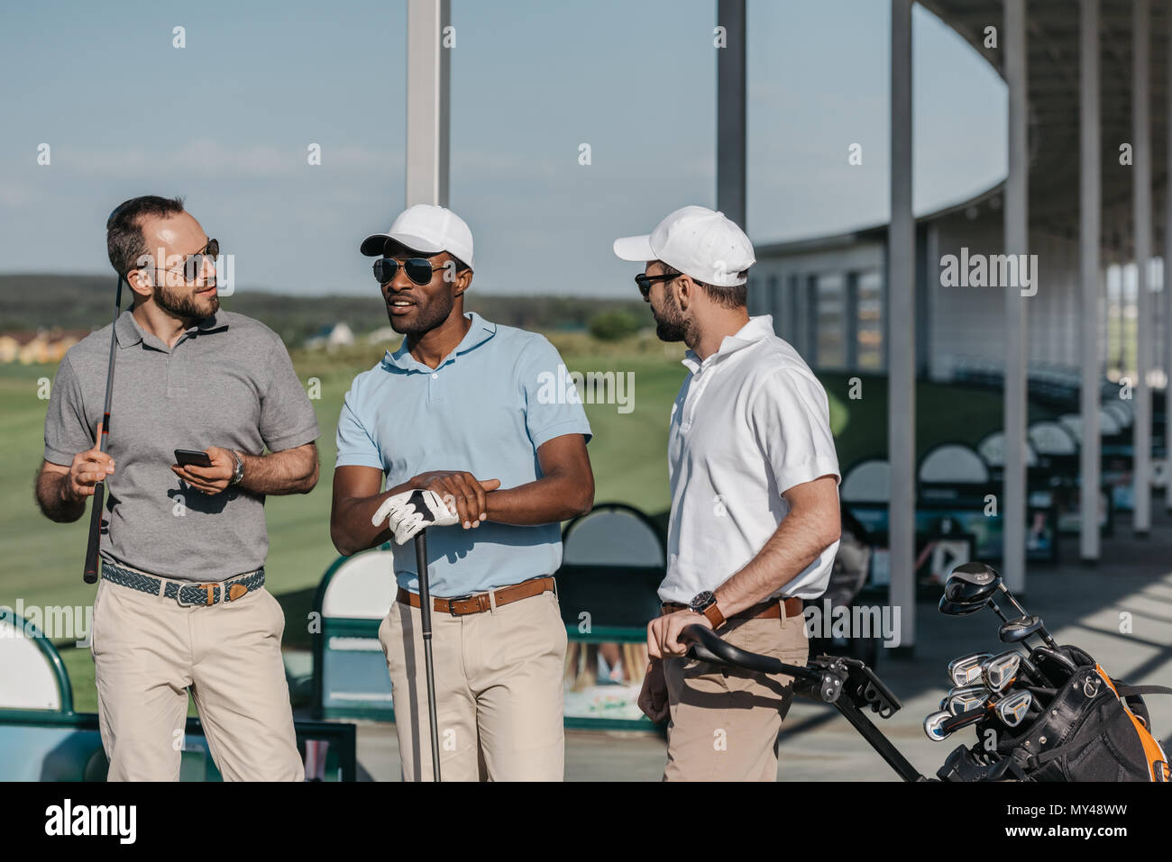 portrait of group of stylish golf players talking before game Stock ...