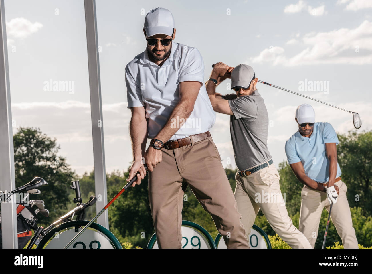 group of friends playing golf together at golf course Stock Photo - Alamy
