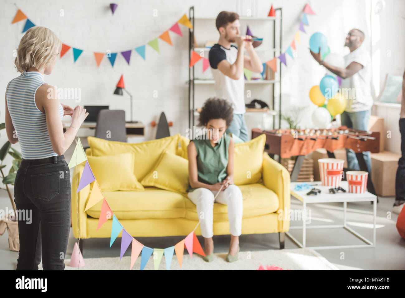 multiethnic young women holding string with party garlands while their ...