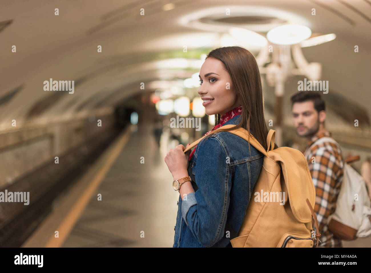 smiling young female traveler with boyfriend at subway station Stock ...