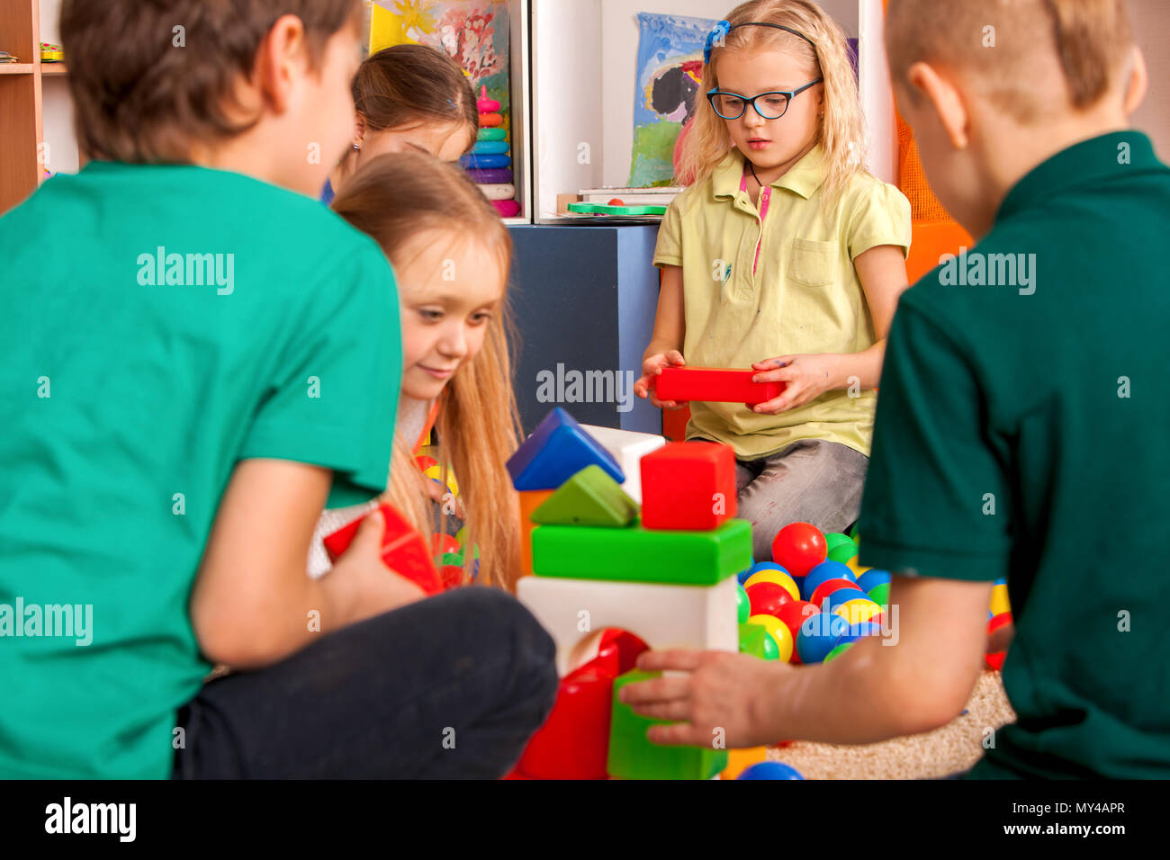 Children building blocks in kindergarten. Group kids playing toy floor ...