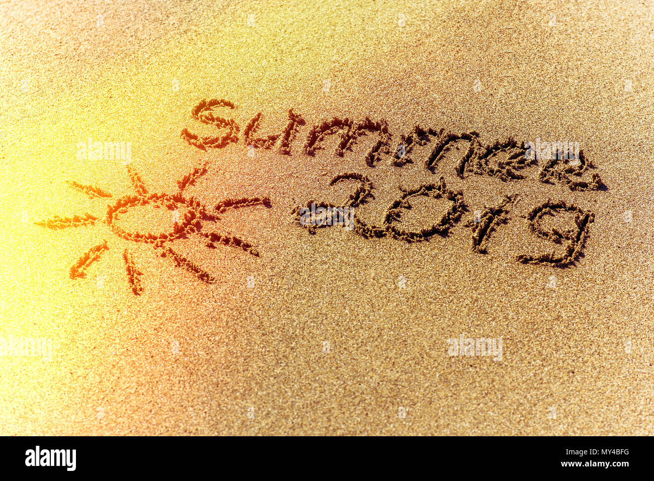 The word summer and sun written in the sand on a beach Stock Photo - Alamy