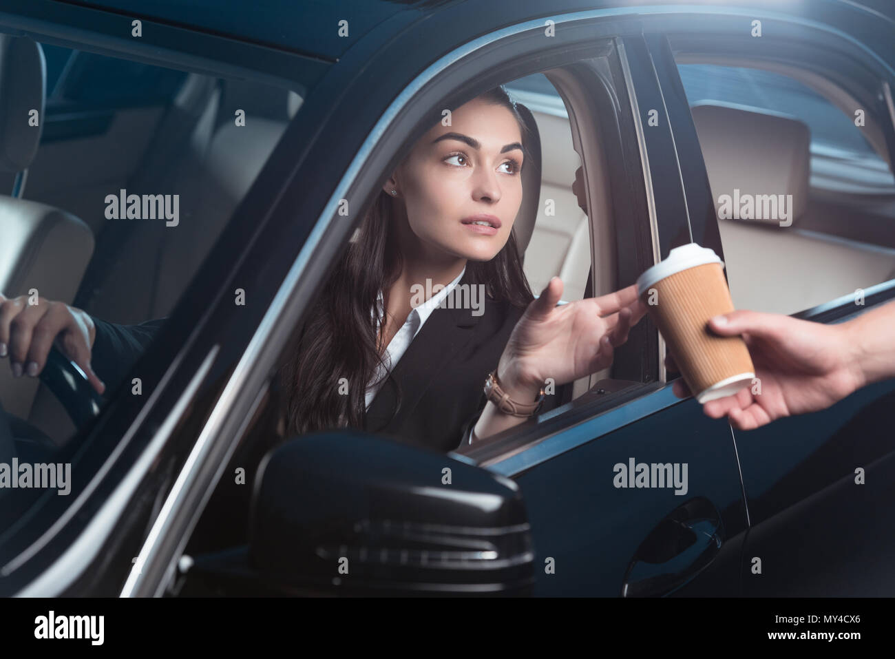 Young beautiful woman in suit sitting in driver seat of car and ...
