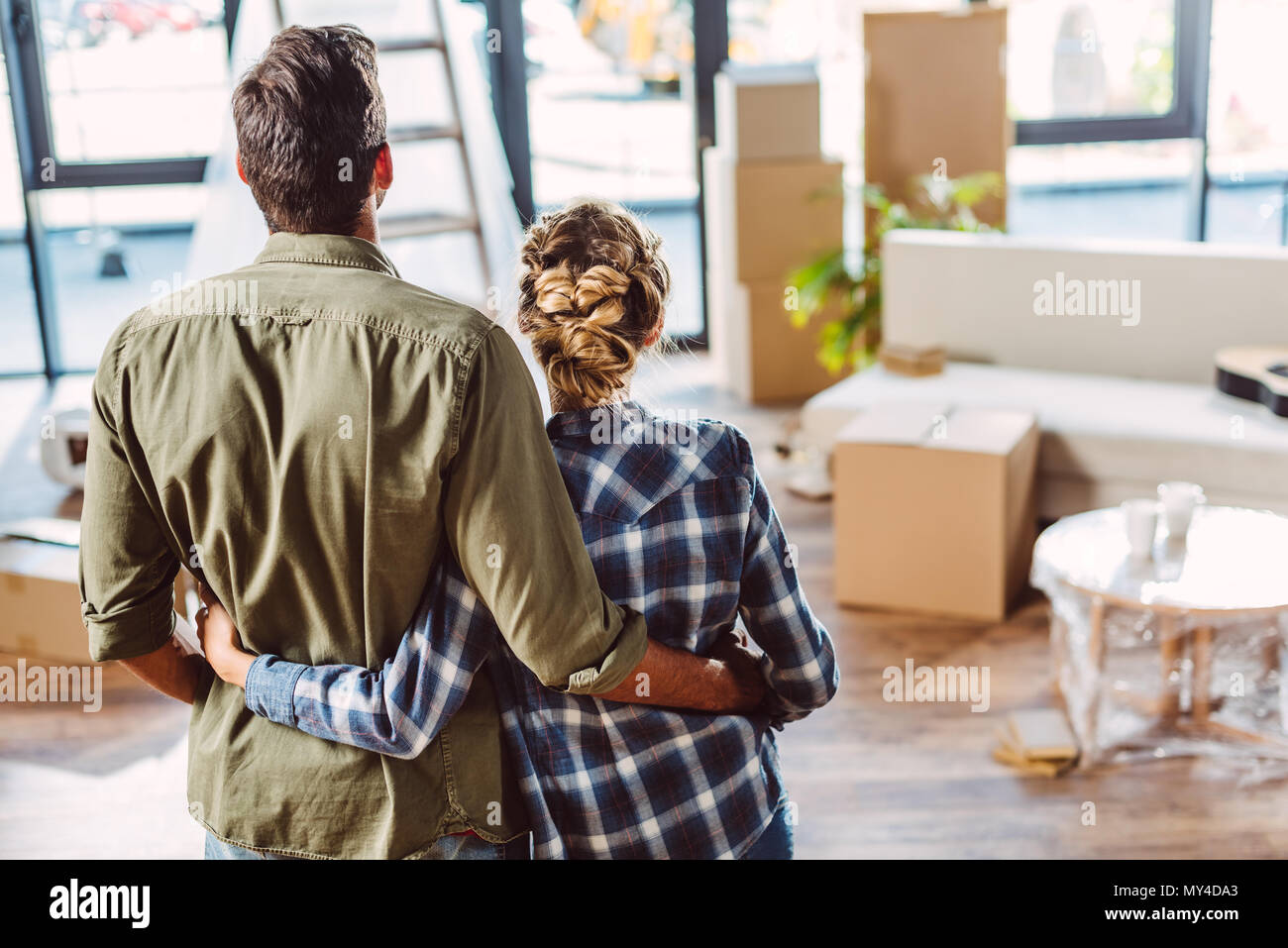back view of young couple embracing in new house Stock Photo - Alamy
