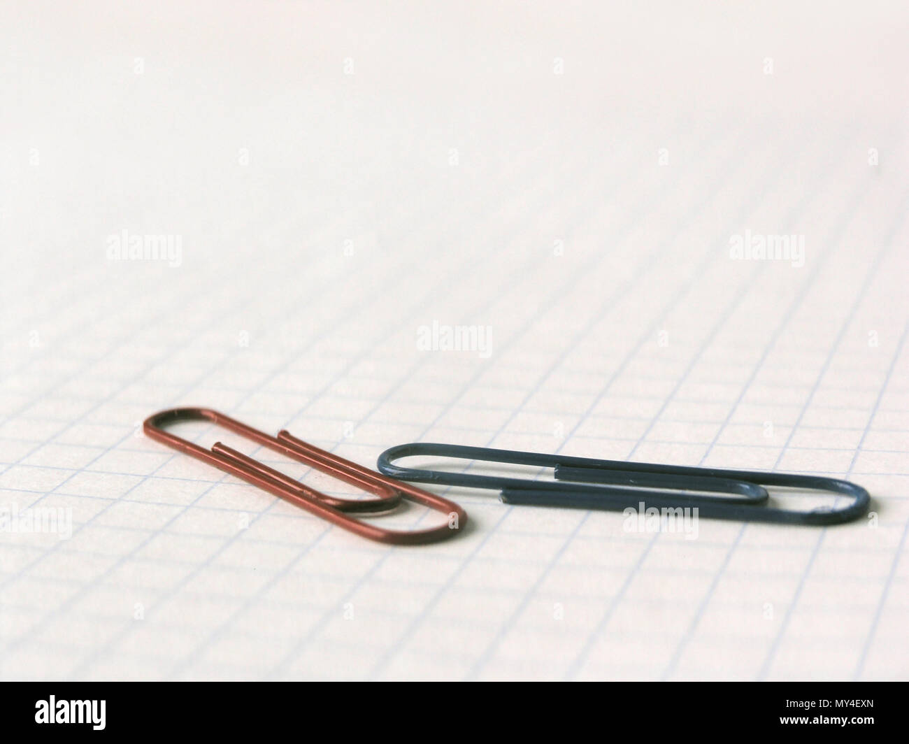 close up.blue and red paper clips on the background of notebook sheet ...