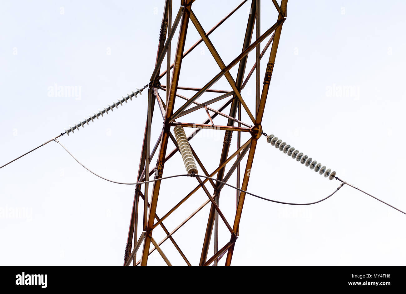 Metal frame girder with insulators holding power cable passing ...