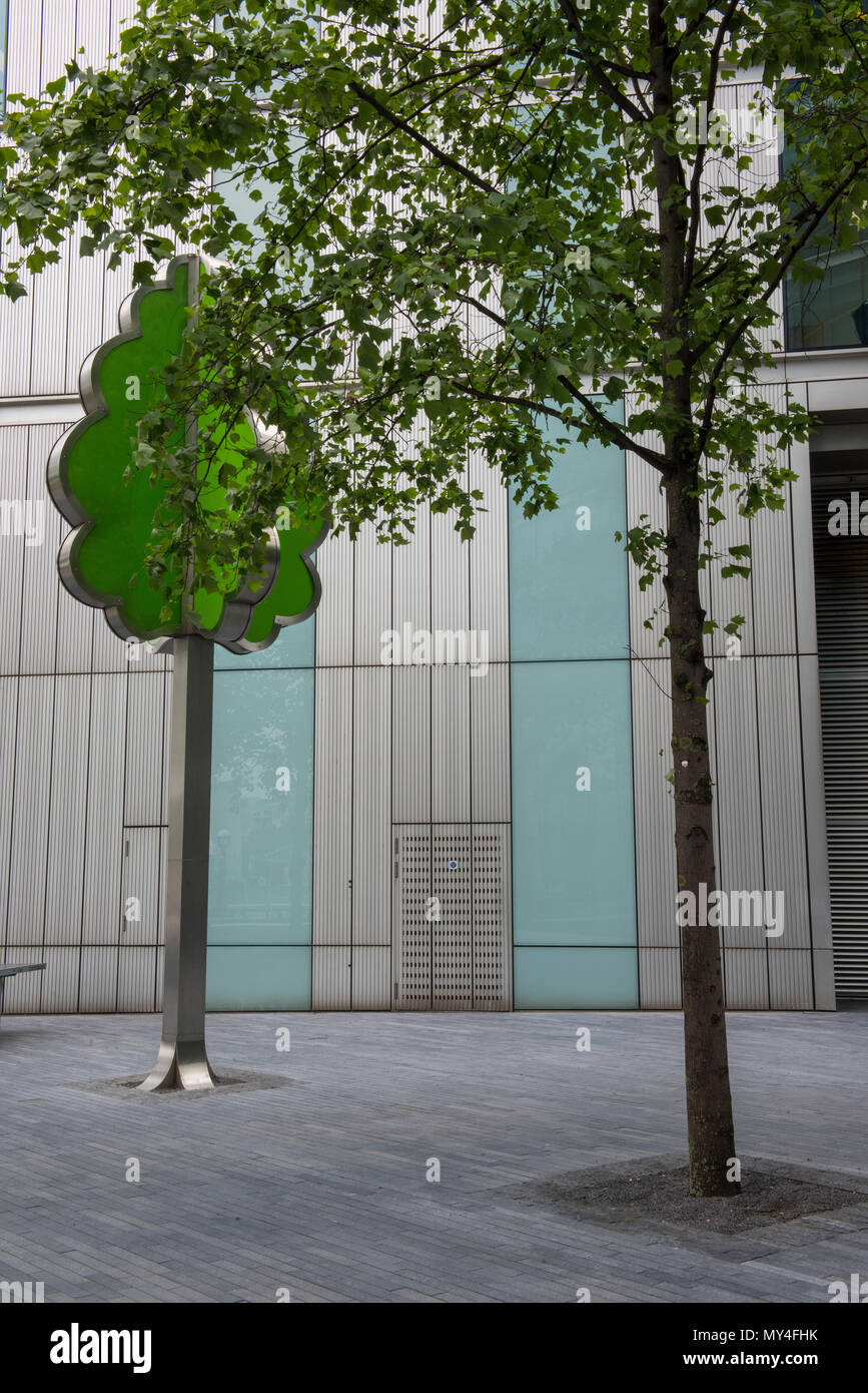 a real living tree next to a replica artificial tree at more london ...