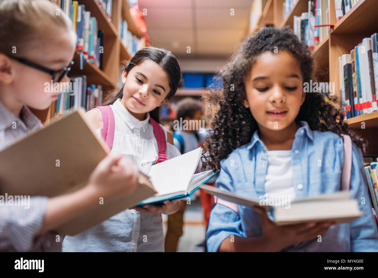 beautiful little schoolgirls looking for books in library Stock Photo ...