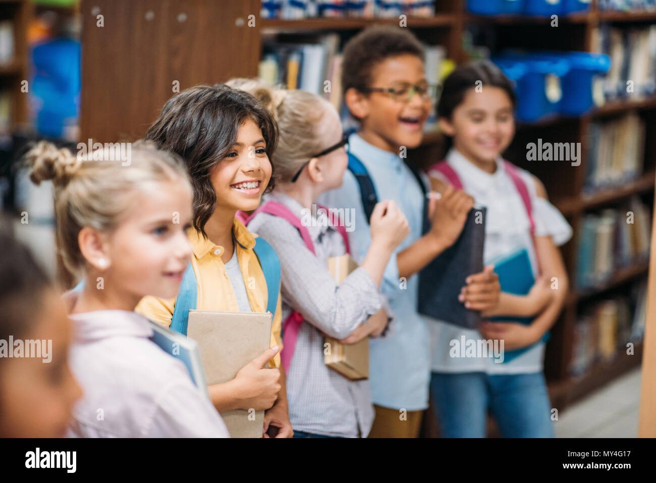 cute kids in library standing in row with books Stock Photo - Alamy