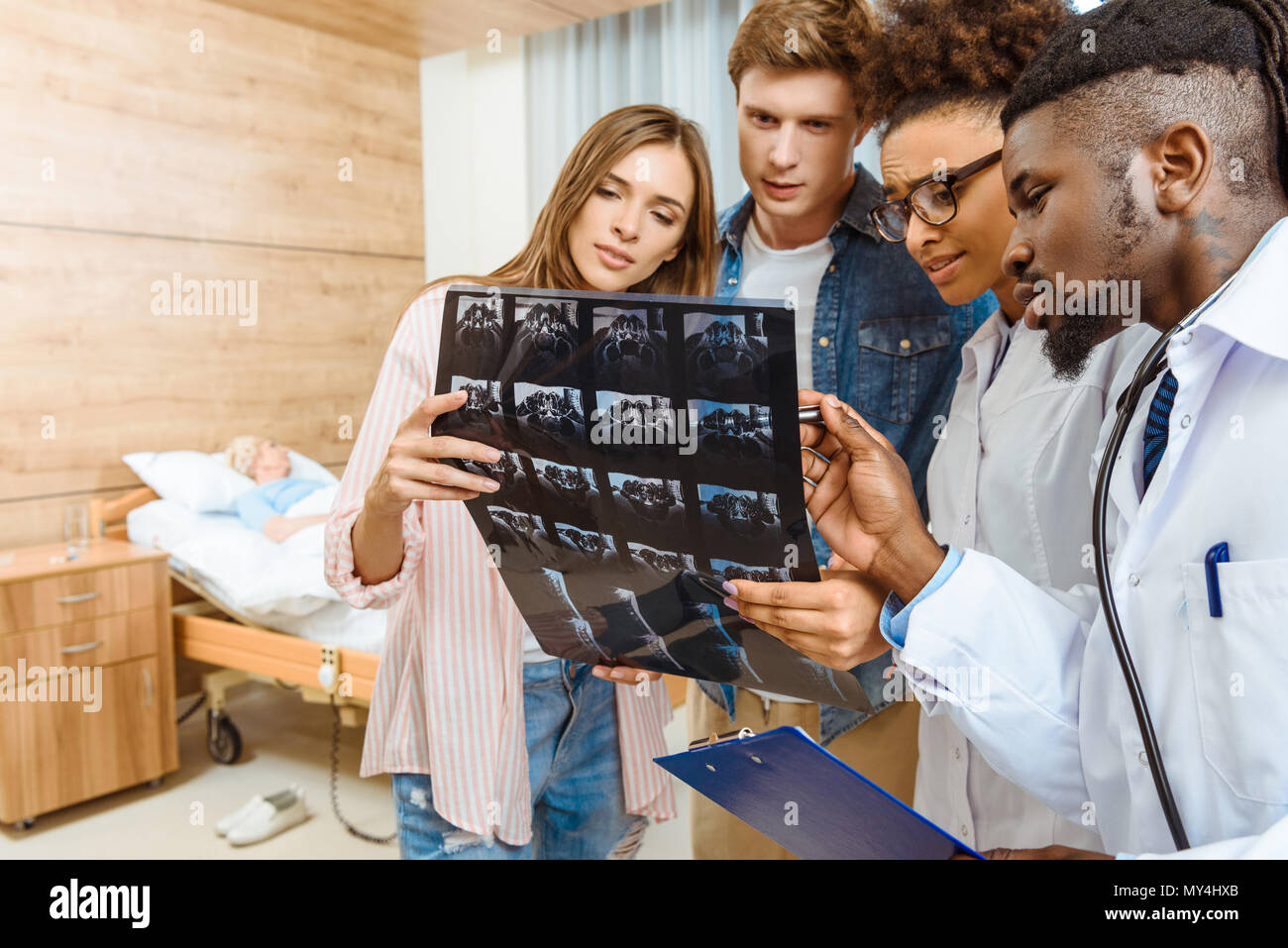 Group of doctors and patients examining X-ray photograph in a hospital ...