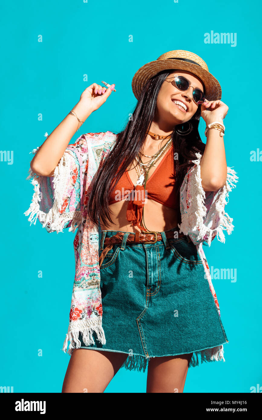 Attractive bohemian girl smoking cigarette and dancing isolated on ...