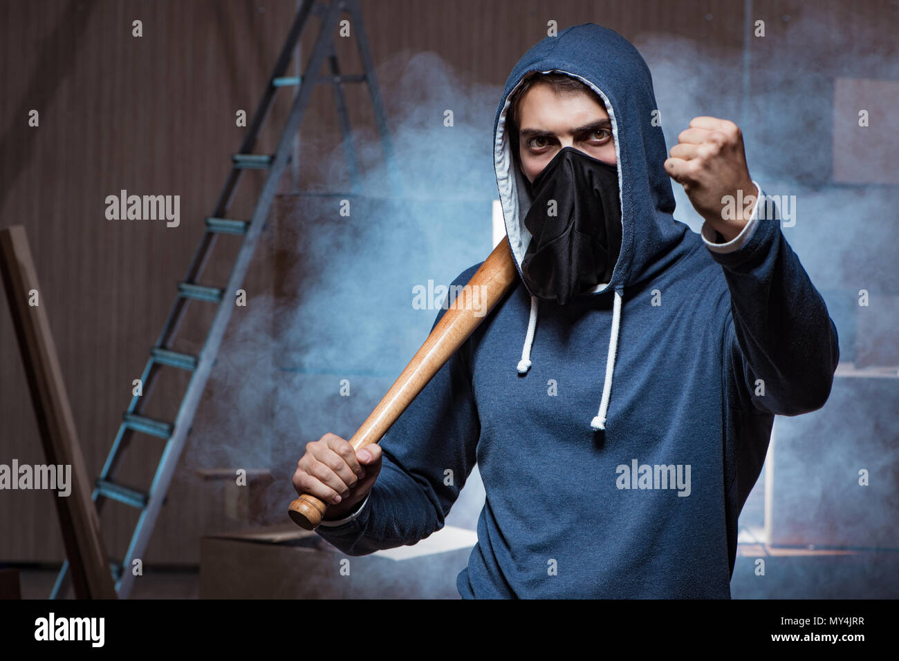 Hooligan with bat in dark room Stock Photo - Alamy