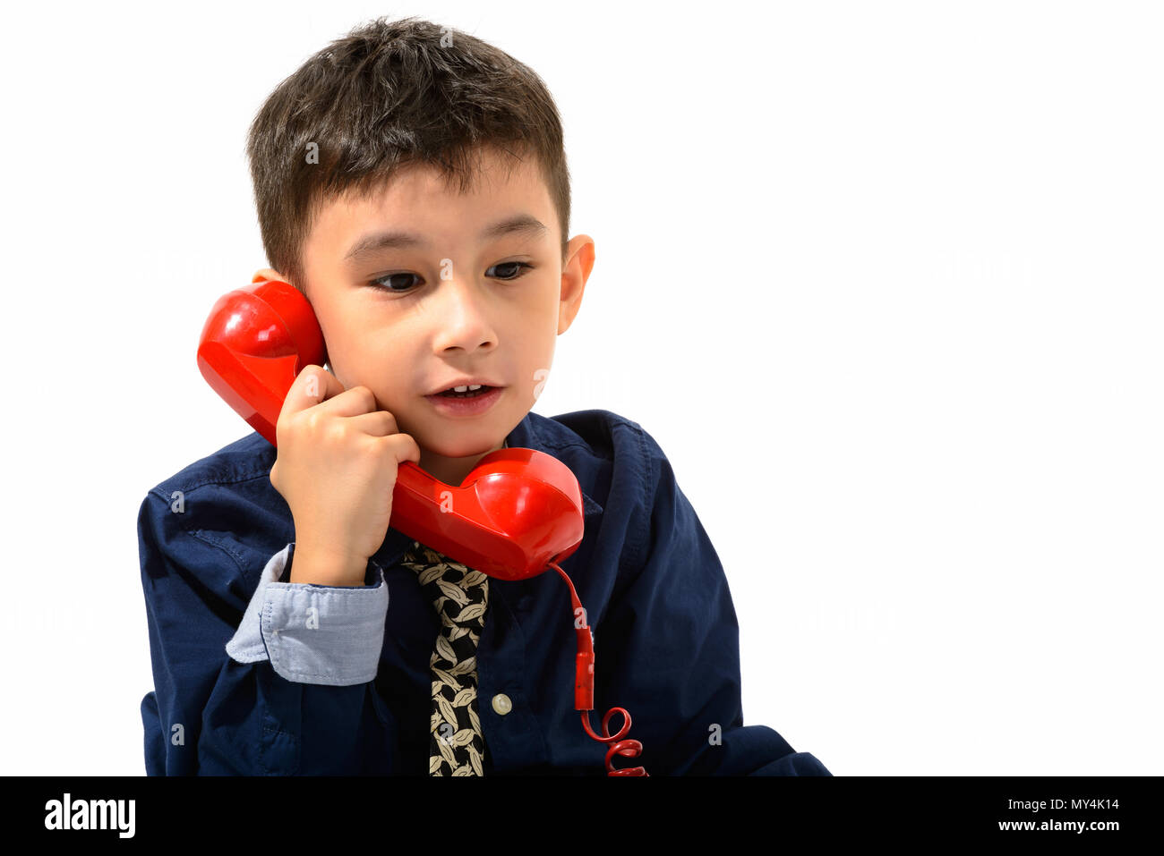 Studio shot of cute boy talking on old telephone and looking dow Stock ...