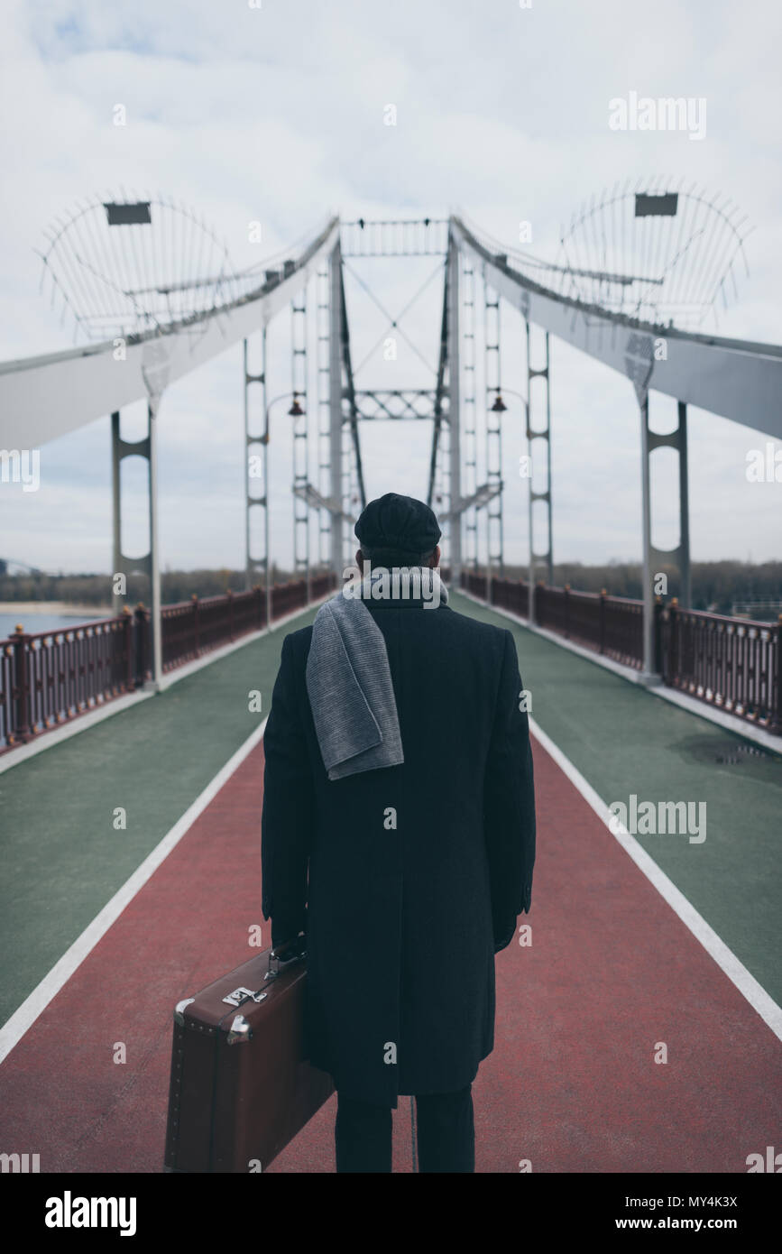 back view of man with suitcase standing on pedestrian bridge Stock ...