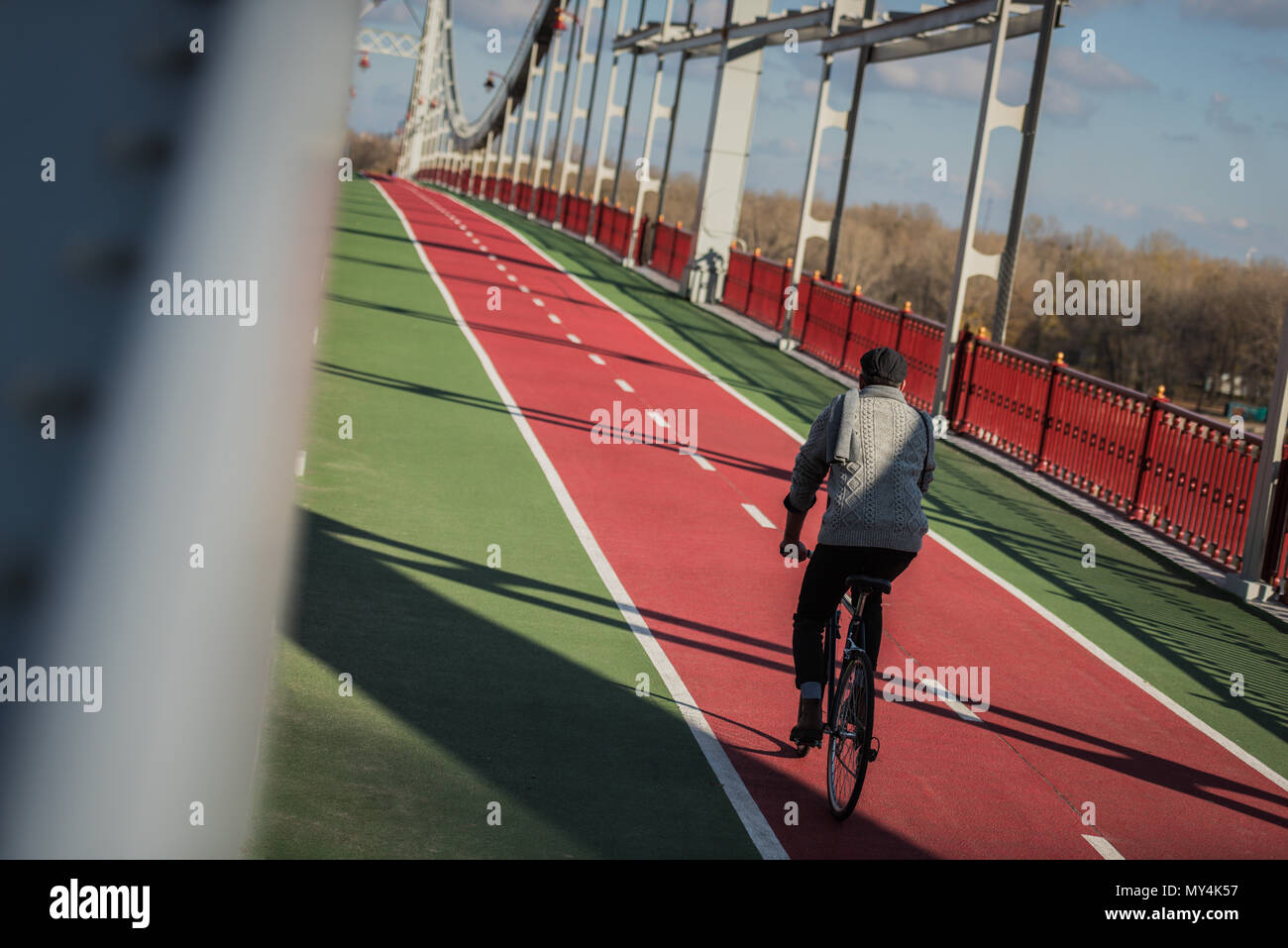 stylish man riding bicycle on pedestrian bridge with biking road Stock ...