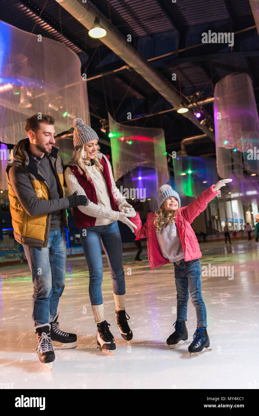 happy young family with one child skating together on rink Stock Photo ...