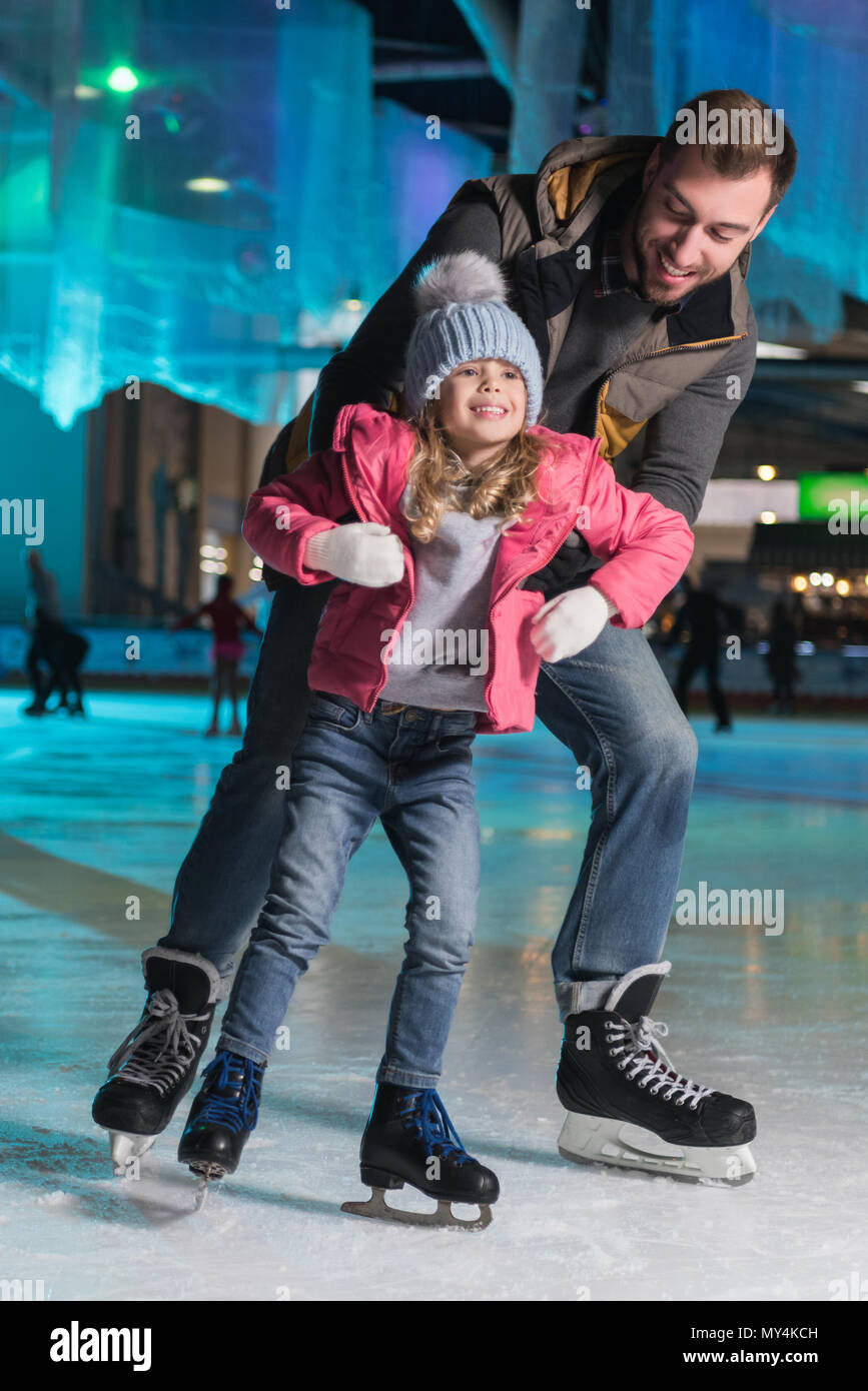 happy father hugging adorable little daughter on skating rink Stock ...