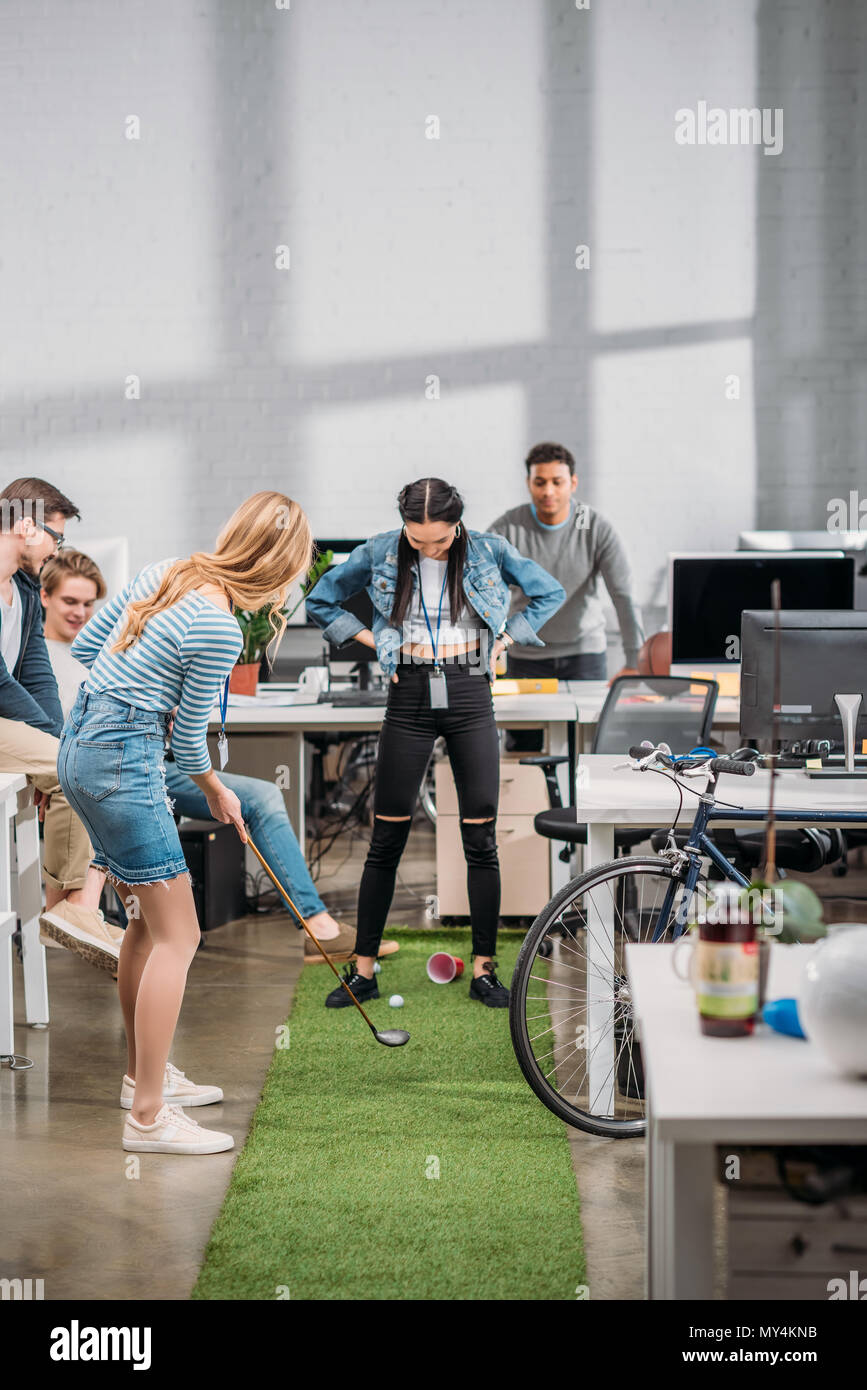 cheerful colleagues playing in mini golf at modern office Stock Photo ...