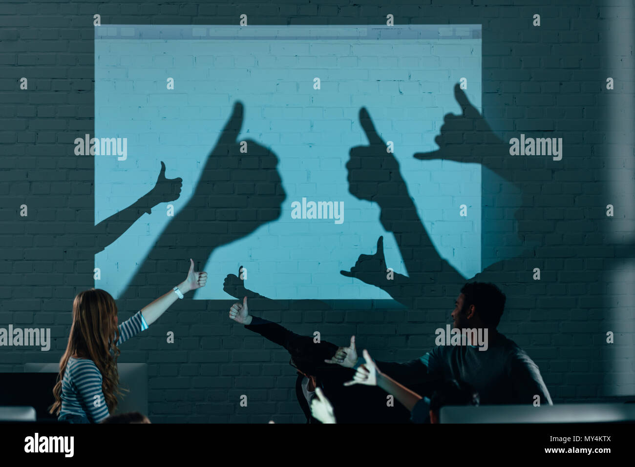 young attractive people playing with shadows after work in modern ...