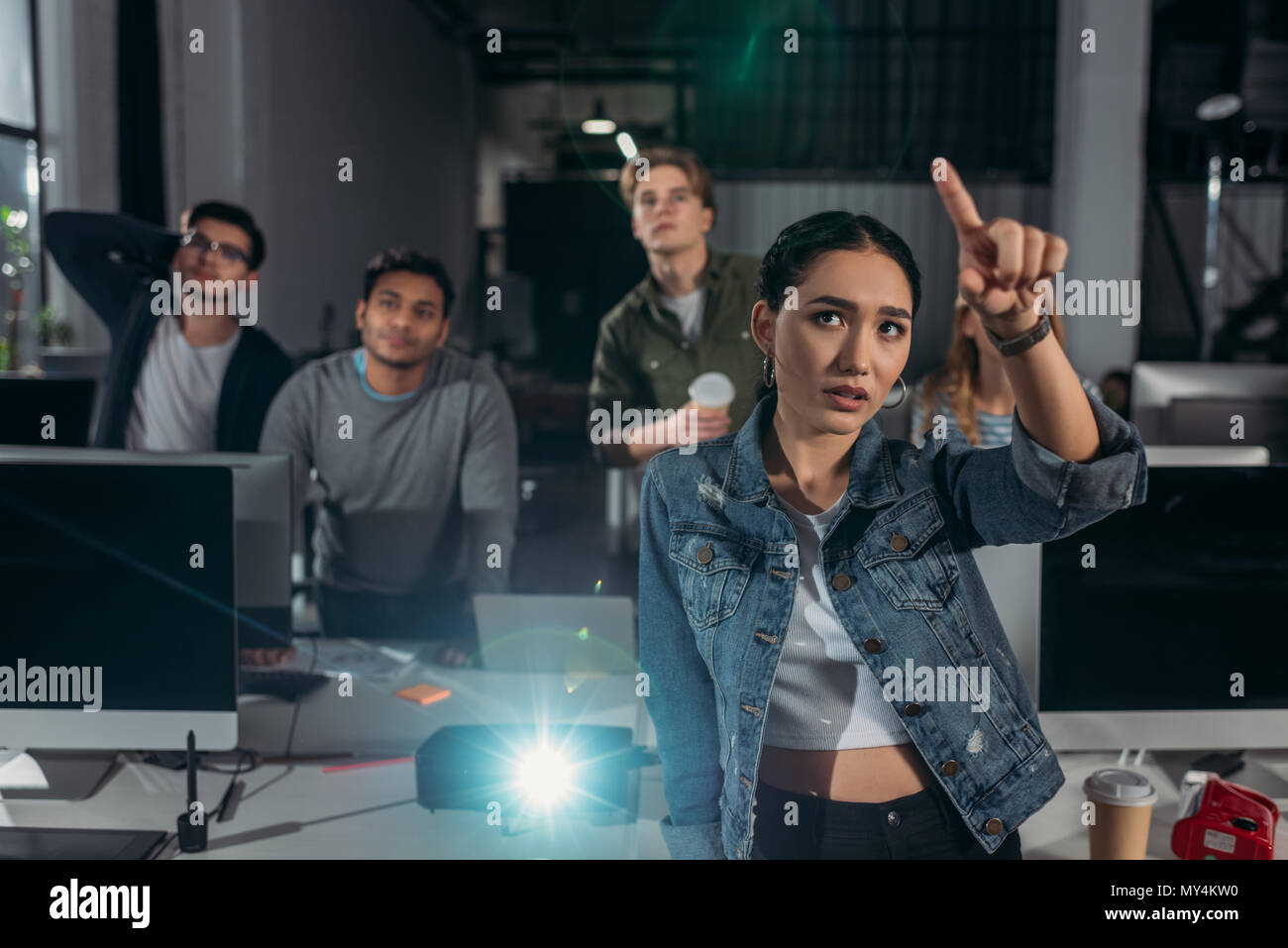 people watching presentation in modern office, woman pointing on screen ...