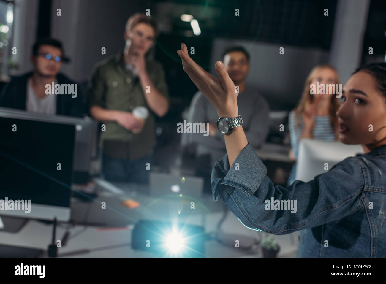 young people watching presentation in modern office, woman pointing on ...