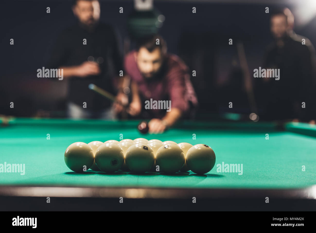 handsome man playing in pool at bar with friends Stock Photo - Alamy