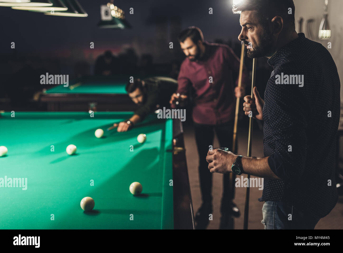 company of handsome men playing in pool at bar Stock Photo - Alamy