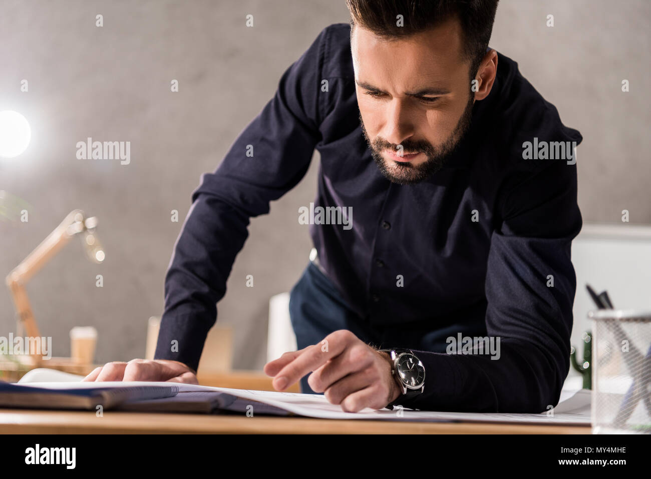 handsome architect looking at blueprints on table Stock Photo - Alamy
