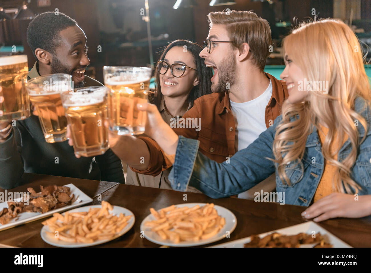 young multiculture company eating and drinking at bar Stock Photo - Alamy