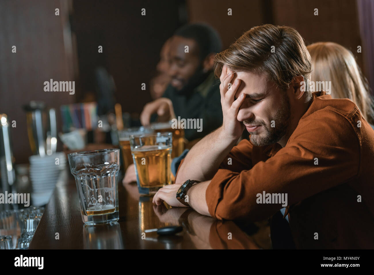 very drunk caucasian man with automobile keys at bar with friends Stock ...