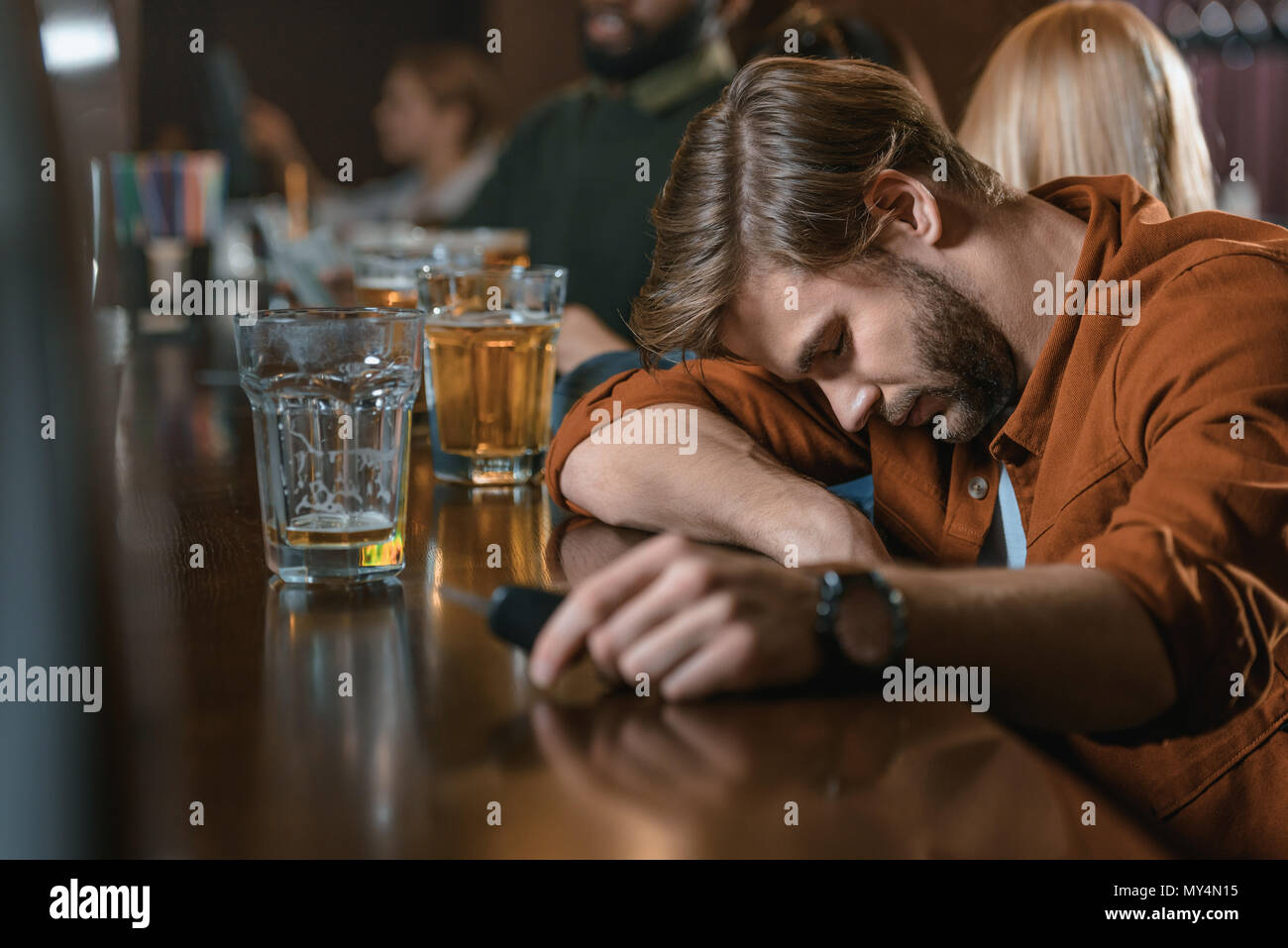 very drunk caucasian man with automobile keys at bar with friends Stock ...