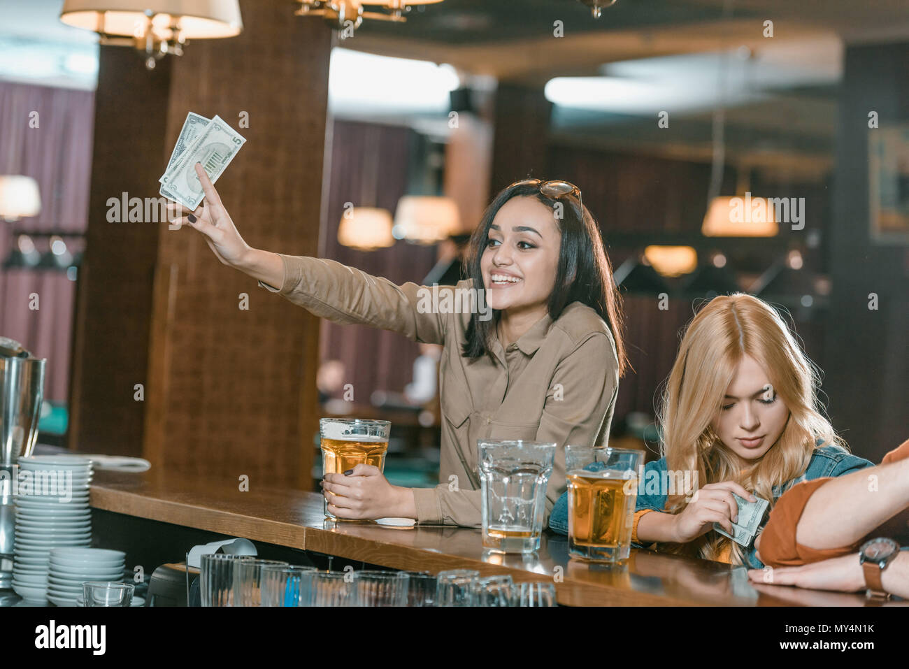 beautiful girl with money paying for drink at bar Stock Photo - Alamy