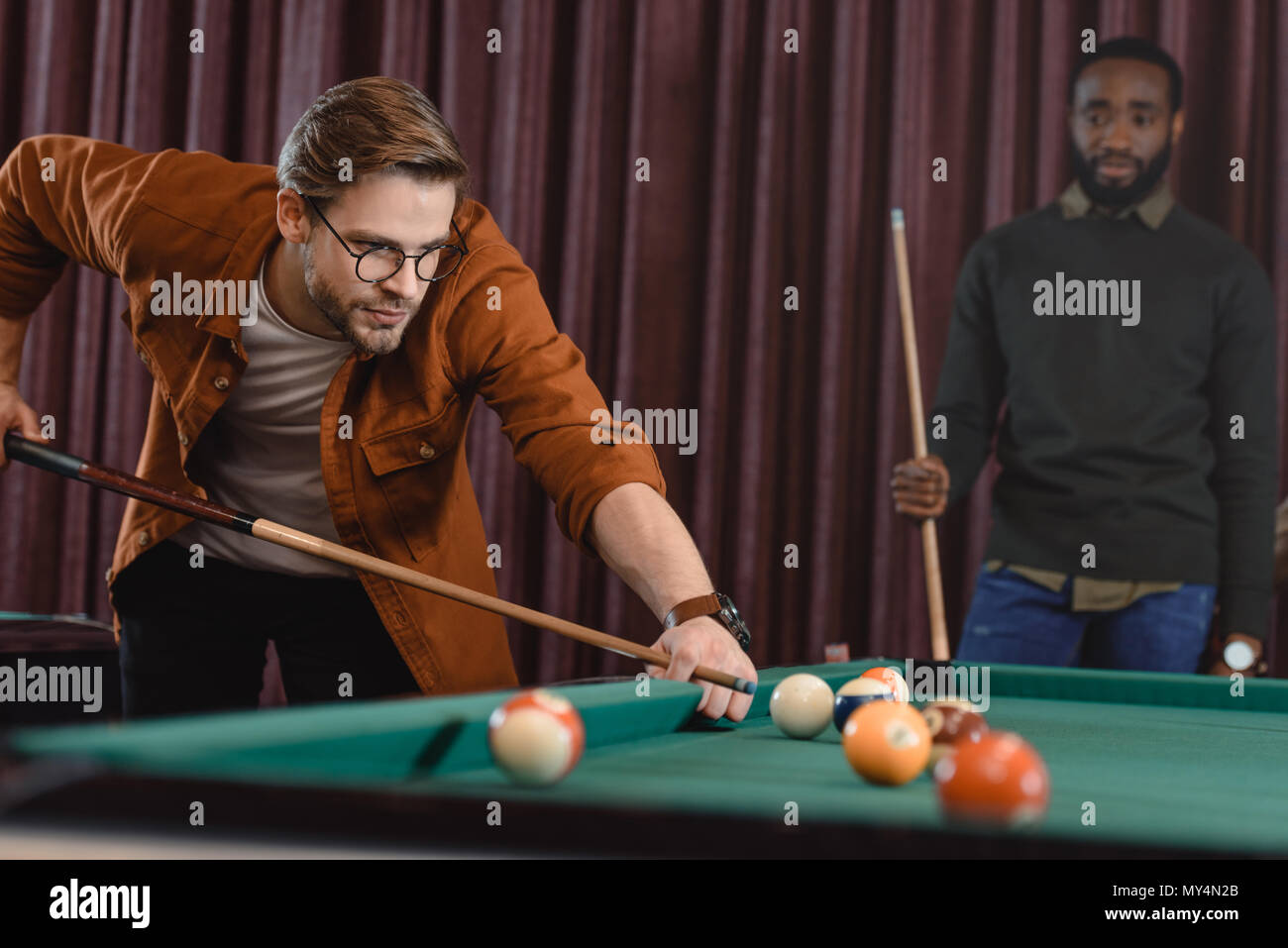 handsome man playing in pool at bar with friend Stock Photo - Alamy
