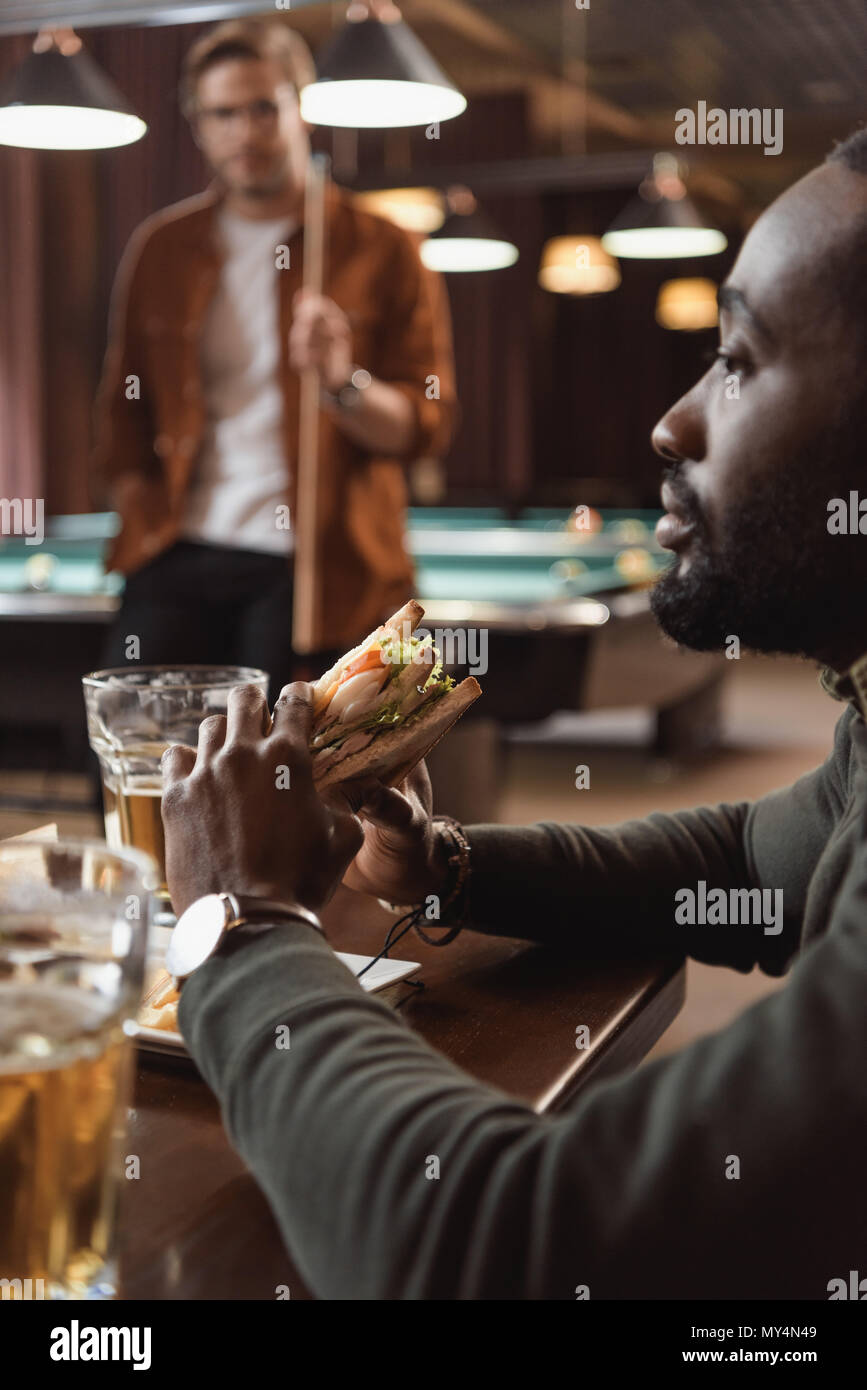 african amercian man eating sandwich at bar Stock Photo - Alamy