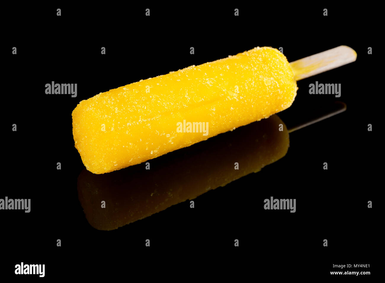 yellow popsicle on a black background with reflection Stock Photo - Alamy