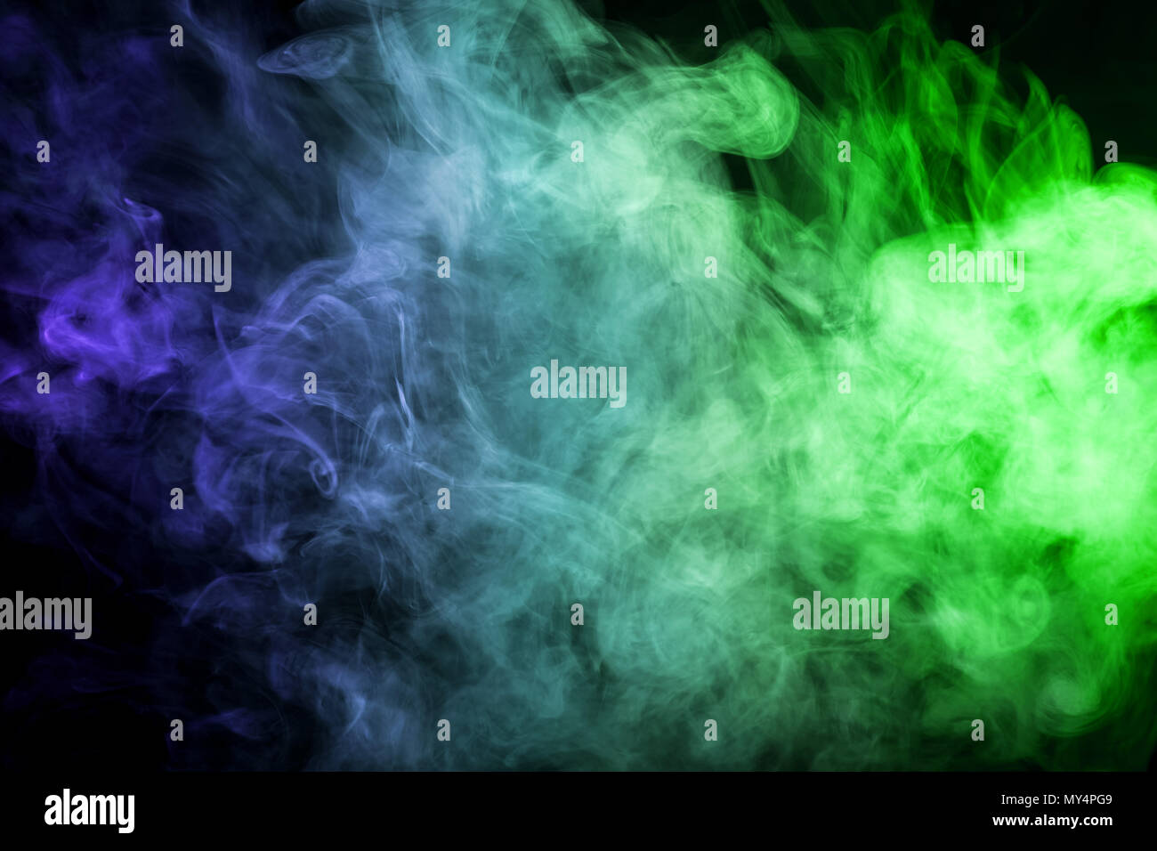 Thick colorful blue and green smoke on a black isolated background ...