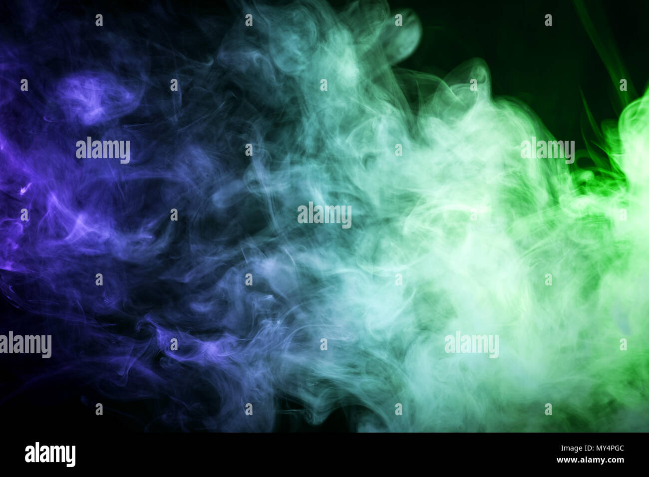 Thick colorful blue and green smoke on a black isolated background ...