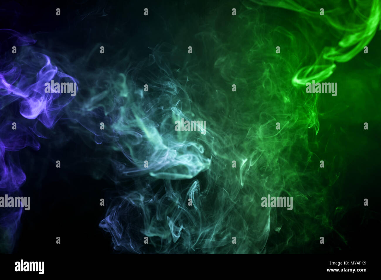 Dense multicolored smoke of blue and green colors on a black isolated ...