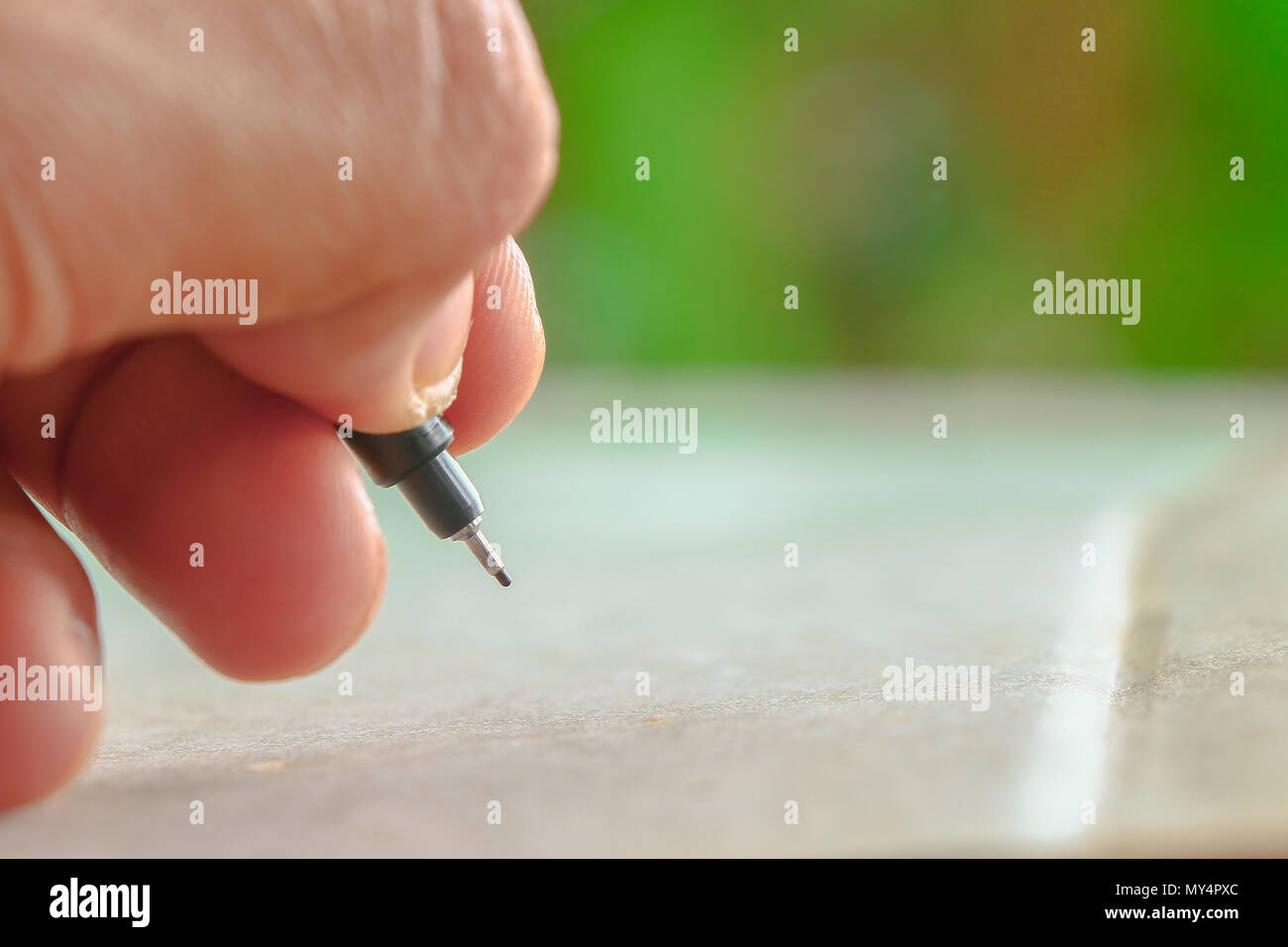 Close up human hand use pen whiting something on paper with nature ...