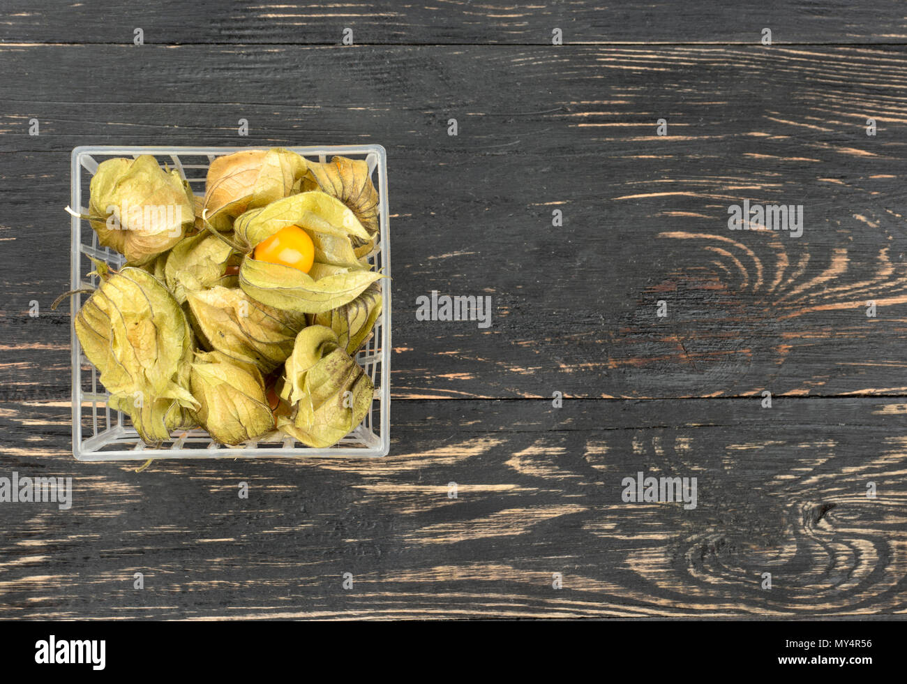 Container with a physalis fruit in peel on empty table, top view Stock ...