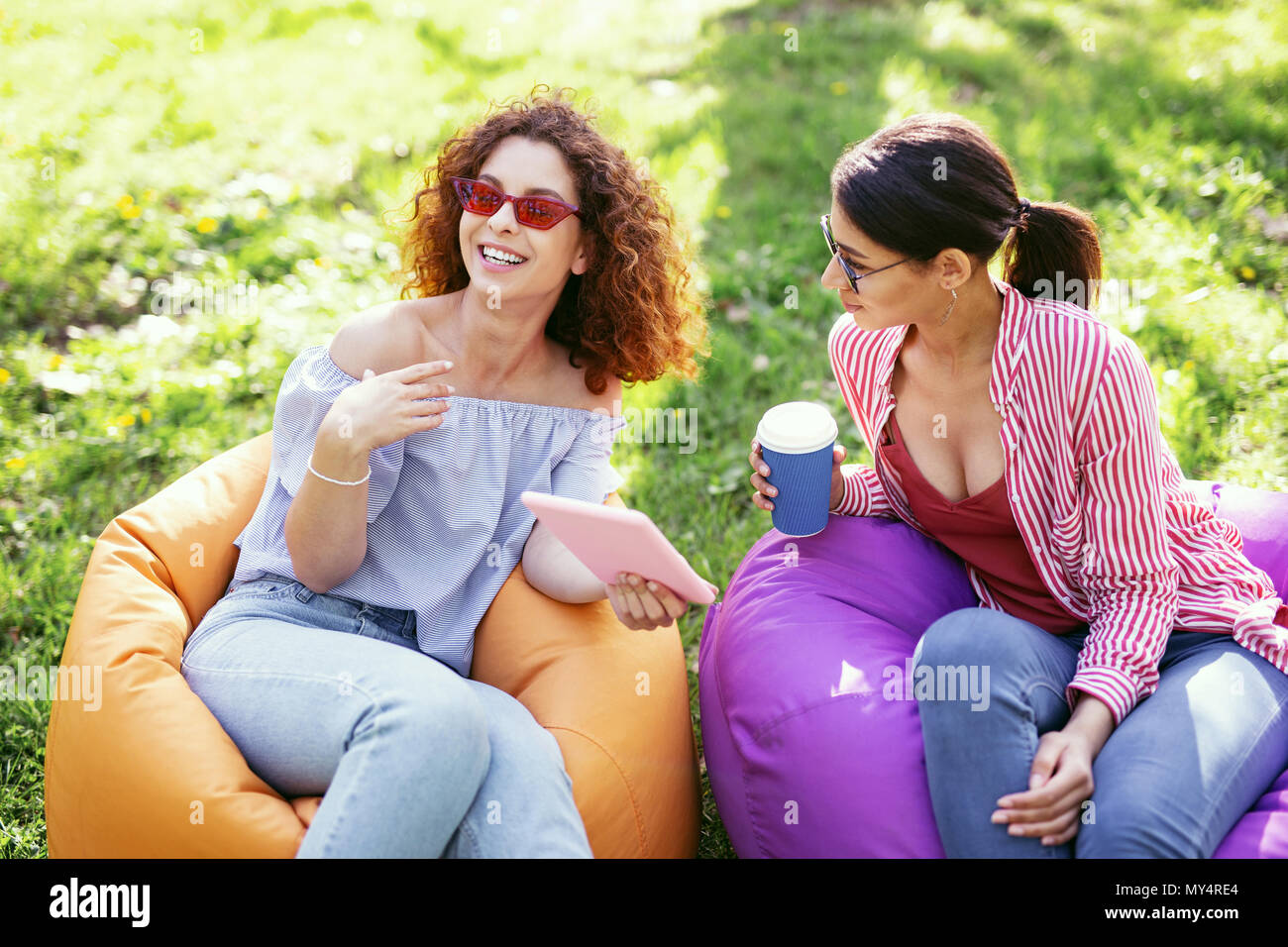 Happy stylish girls talking and relaxing Stock Photo - Alamy