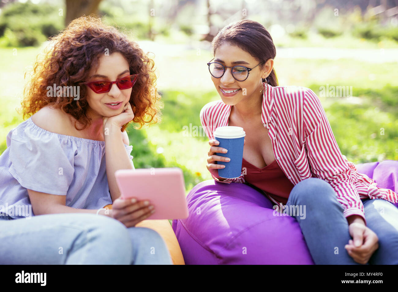 Smiling friends looking through some photos Stock Photo - Alamy
