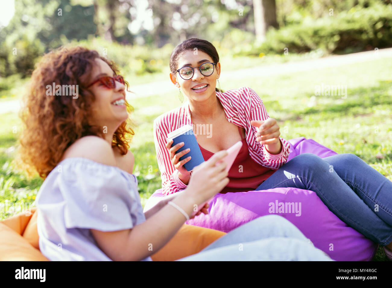 Glad young women talking and relaxing Stock Photo - Alamy
