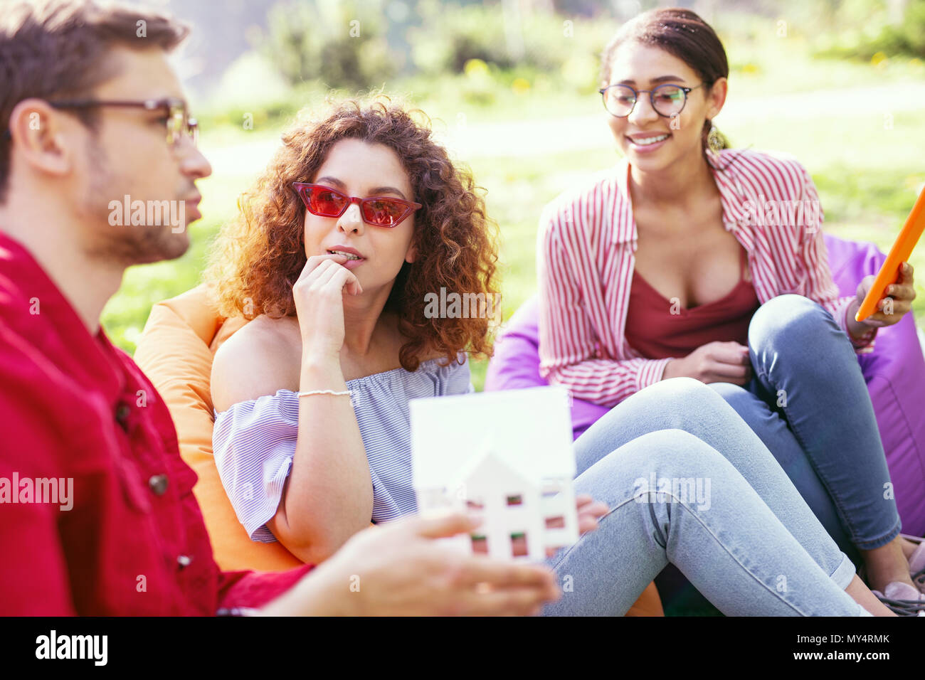 Alert woman discussing work with her co-workers Stock Photo - Alamy