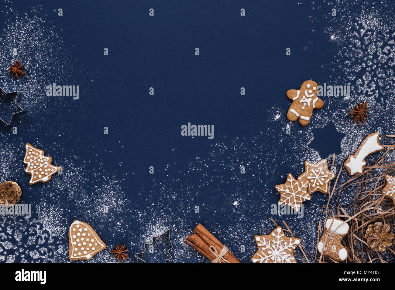 Christmas background with gingerbread and snow on navy colored surface ...