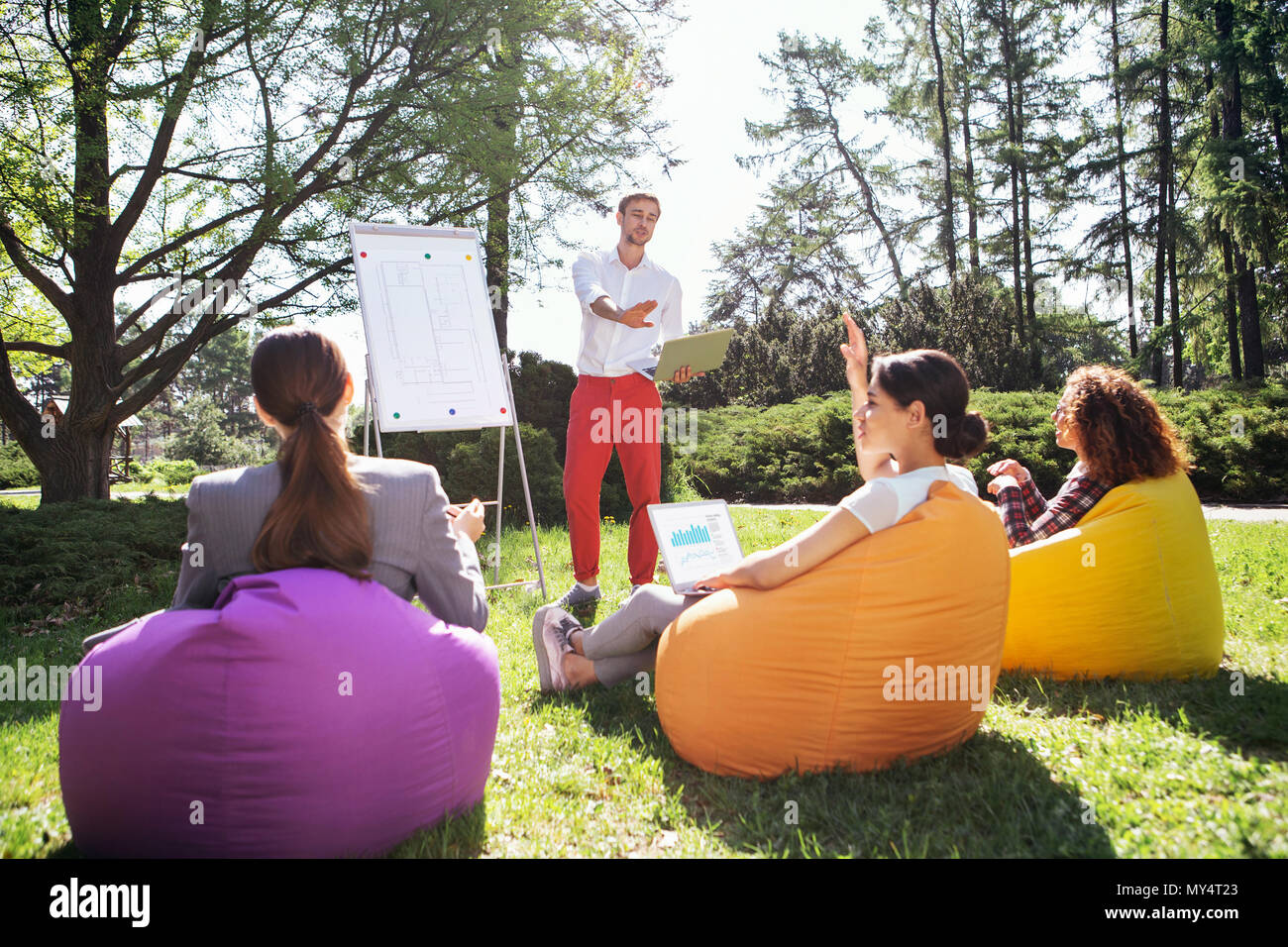 Alert man talking with his friends about the project Stock Photo - Alamy