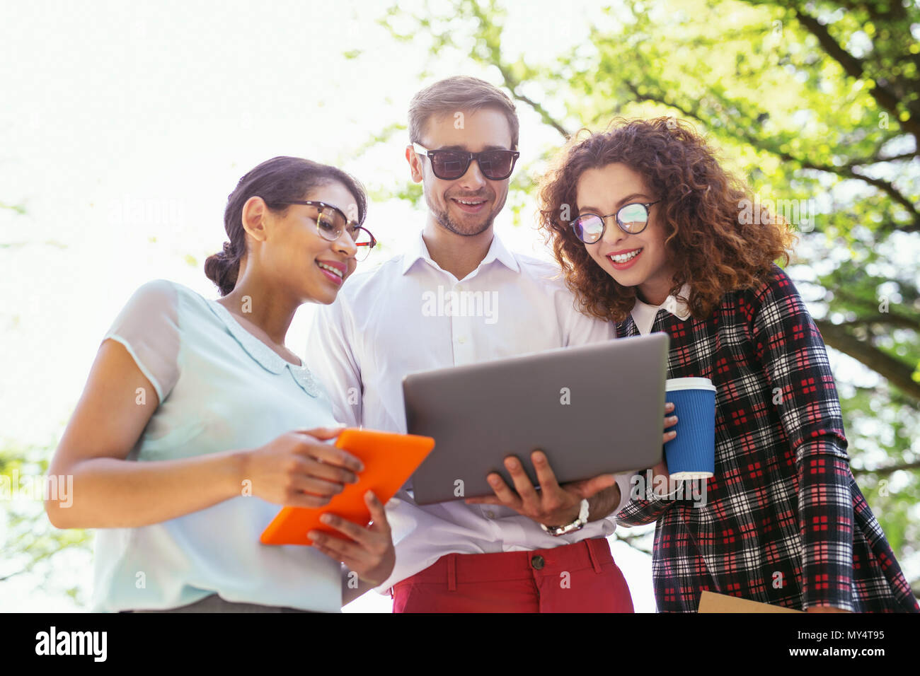 Happy male student holding his laptop Stock Photo - Alamy