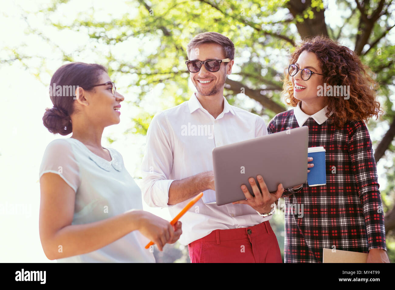 Joyful male student holding his laptop Stock Photo - Alamy