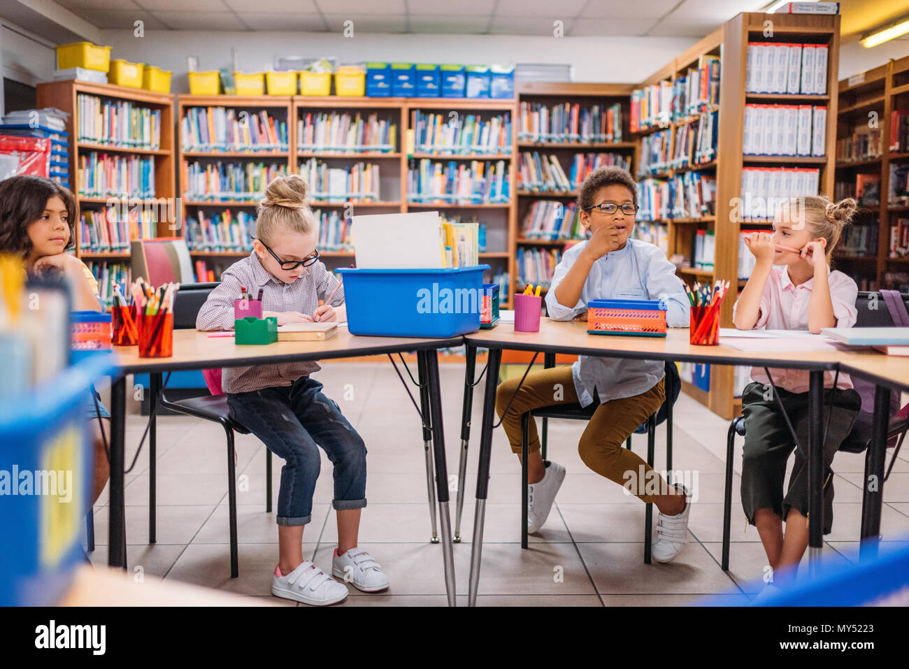 beautiful little kids sitting in library Stock Photo - Alamy